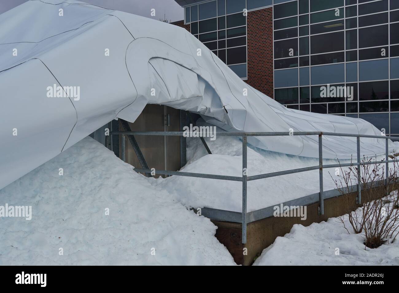 Collapsed inflatable sport dome, after winter snow storm deflated it ...