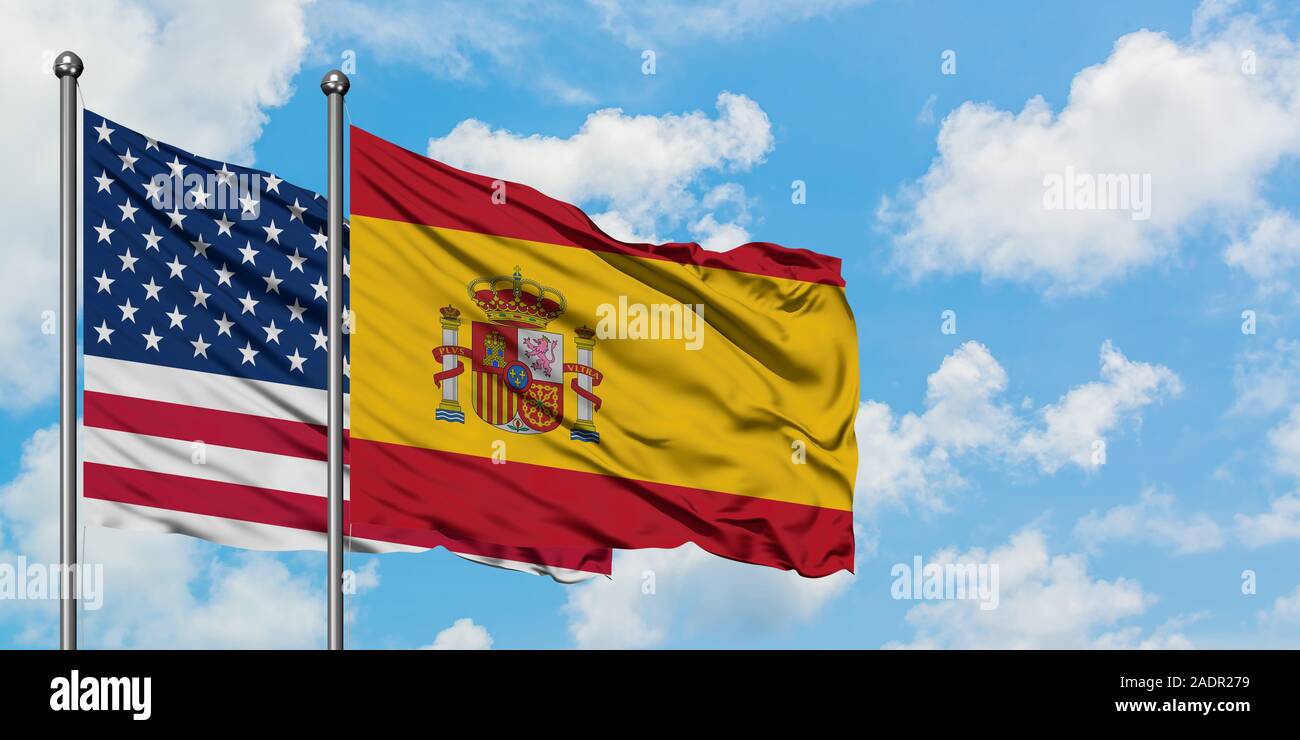 United States and Spain flag waving in the wind against white cloudy ...