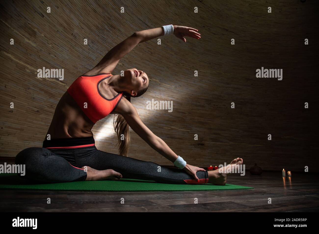 Full length of fit young woman putting hand over the head at yoga class ...