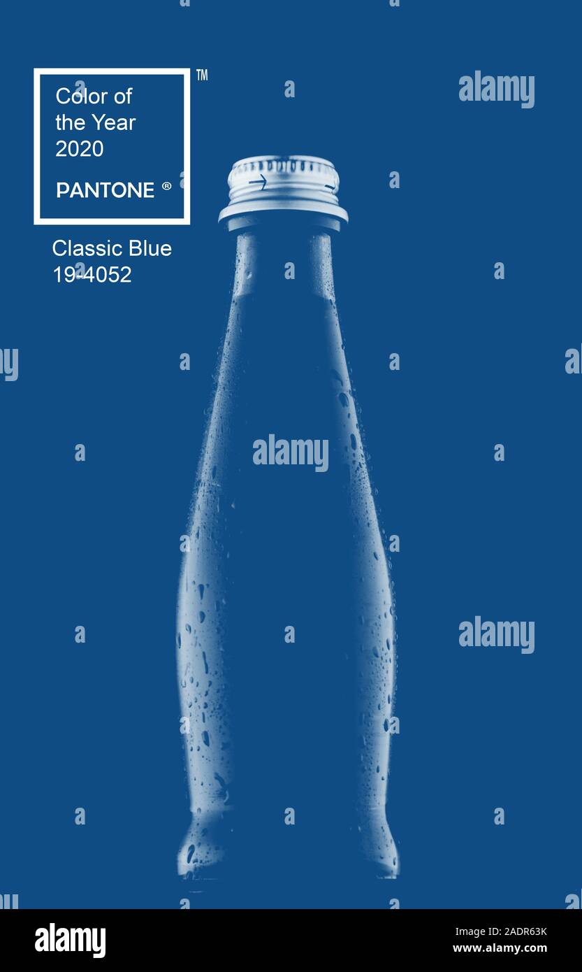 Glass bottle with water in a tinted trendy color 2020. Classic blue ...