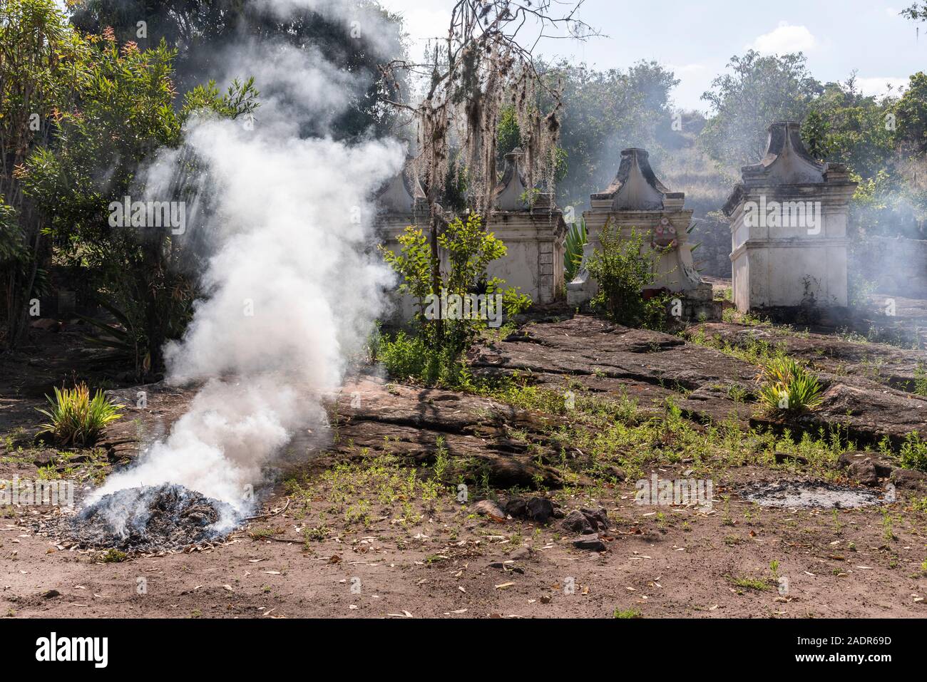 Smoke burning near byzantine style white tomb stones on cemetery next ...