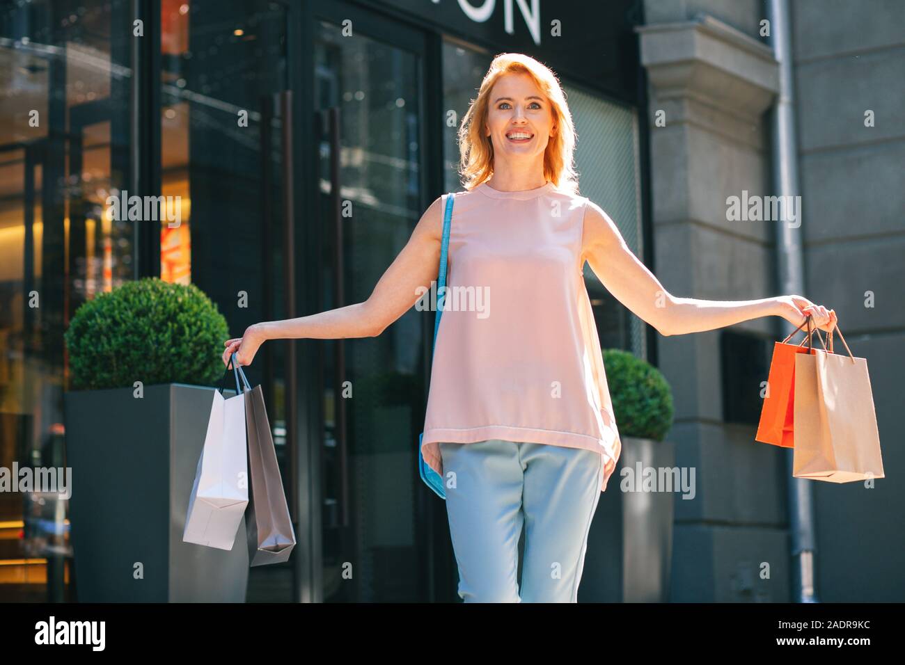 Walking with purchases and looking glad stock photo Stock Photo - Alamy
