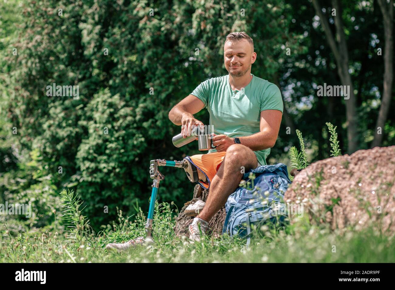 Cheerful man with paralysis resting outdoors with pleasure Stock Photo ...