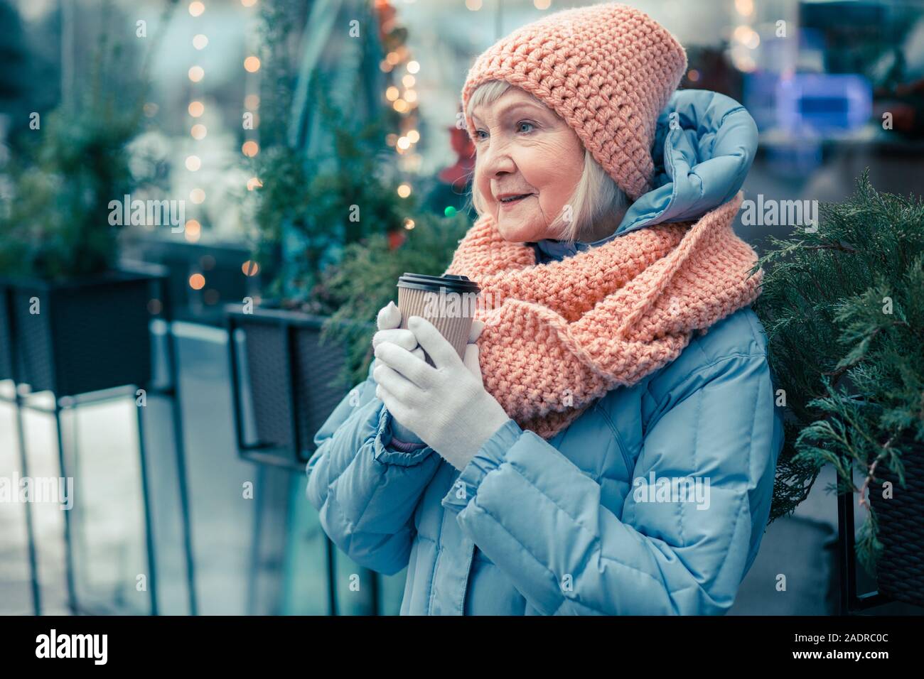 Thoughtful pensioner enjoying coffee outdoors in cold day Stock Photo ...