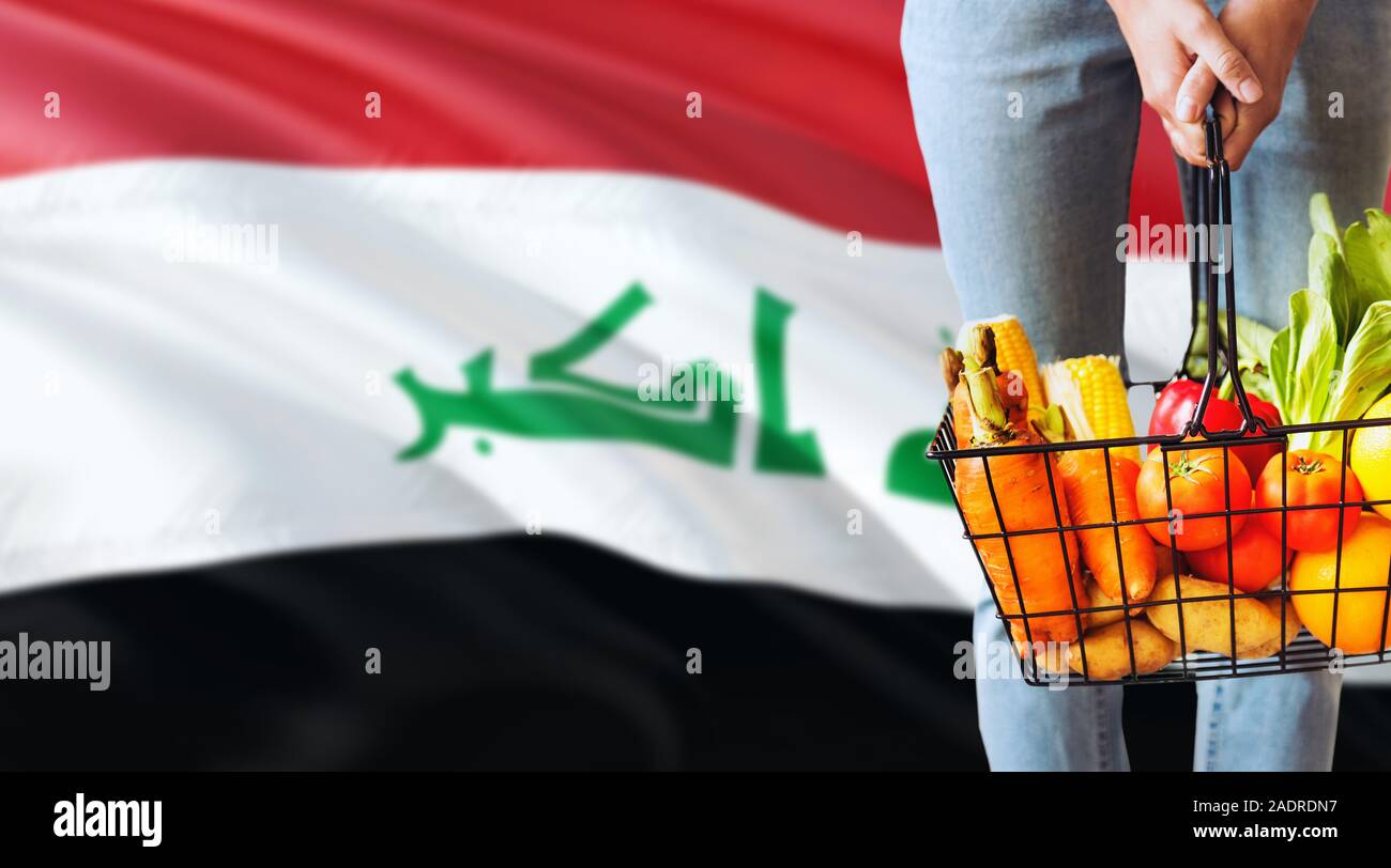 Woman is holding supermarket basket, Iraq waving flag background ...