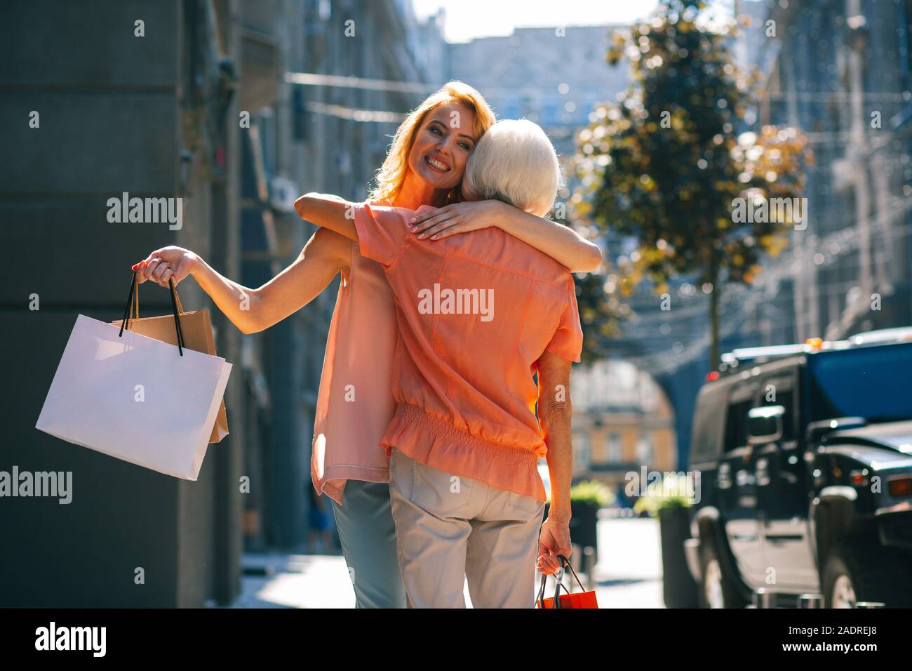 Kind lady with shopping bags hugging her mother stock photo Stock Photo ...
