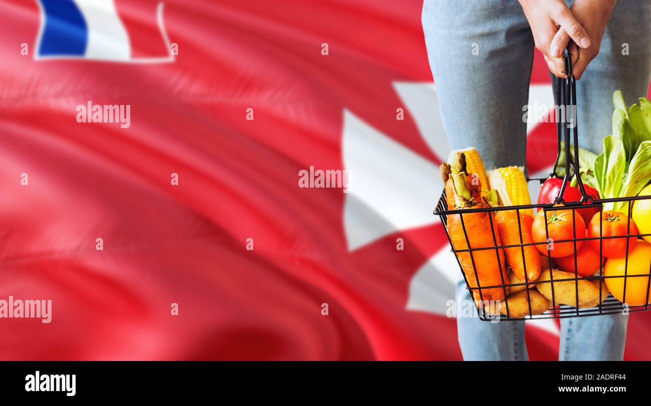 Woman is holding supermarket basket, Wallis And Futuna waving flag ...