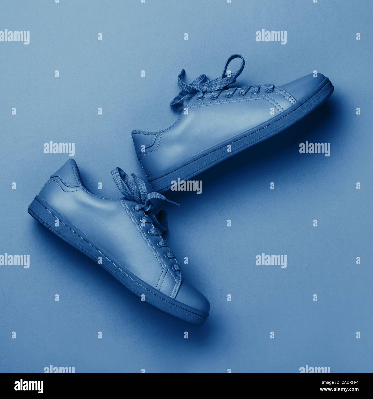 Pair of blue shoes on classic blue background. Trendy color of 2020 ...