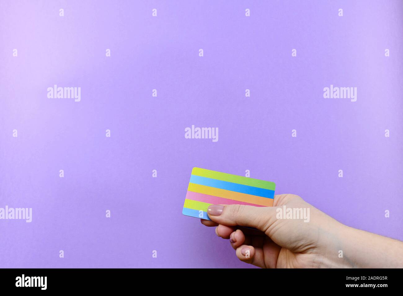 Demonstration of a multi-colored striped card in a hand on a purple ...