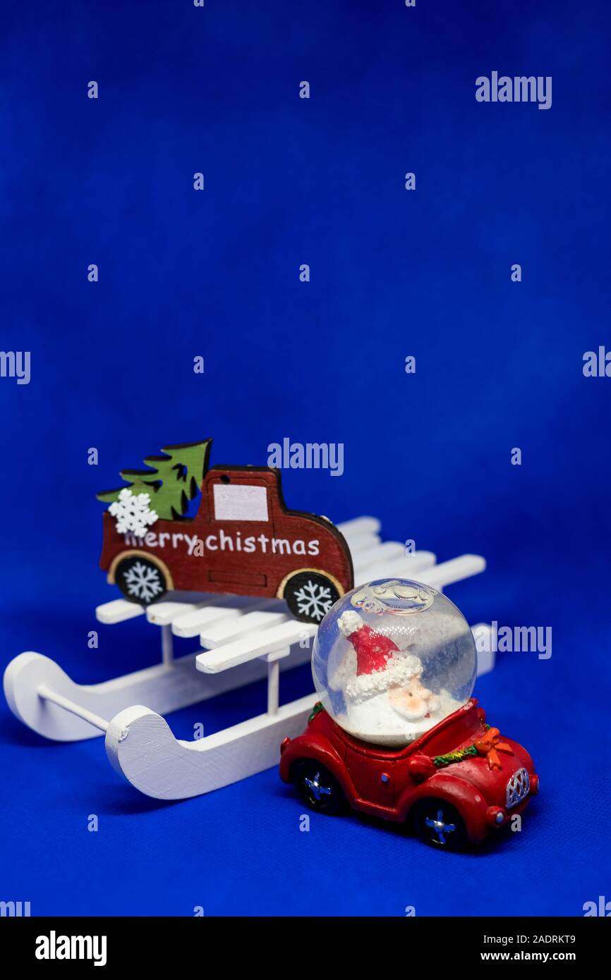 Wooden sledge, toy car with christmas tree isolated on blue background ...