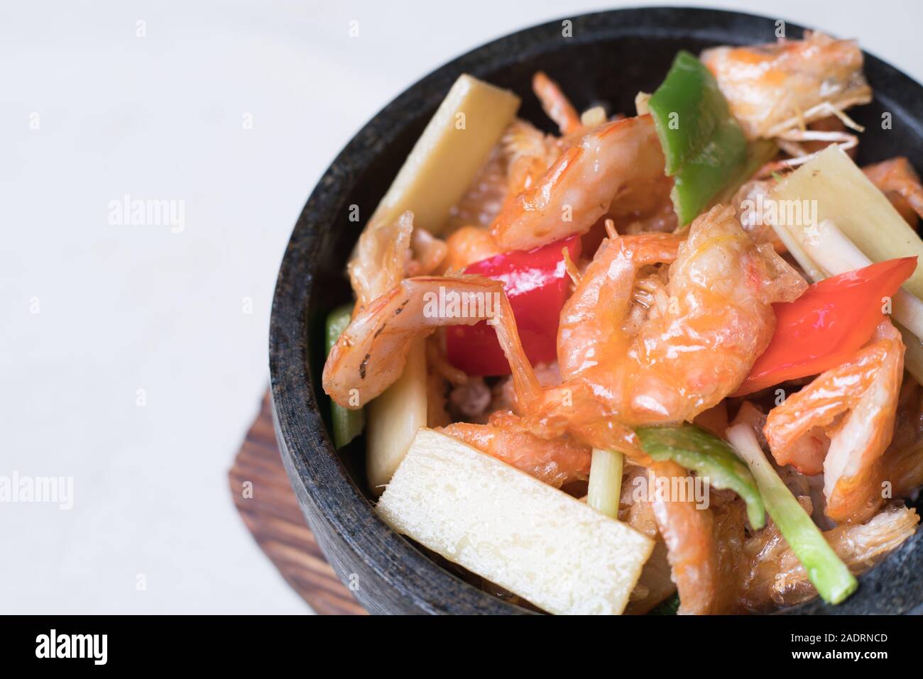 Shrimp stir fry in a wok with serving plates in the background Stock ...