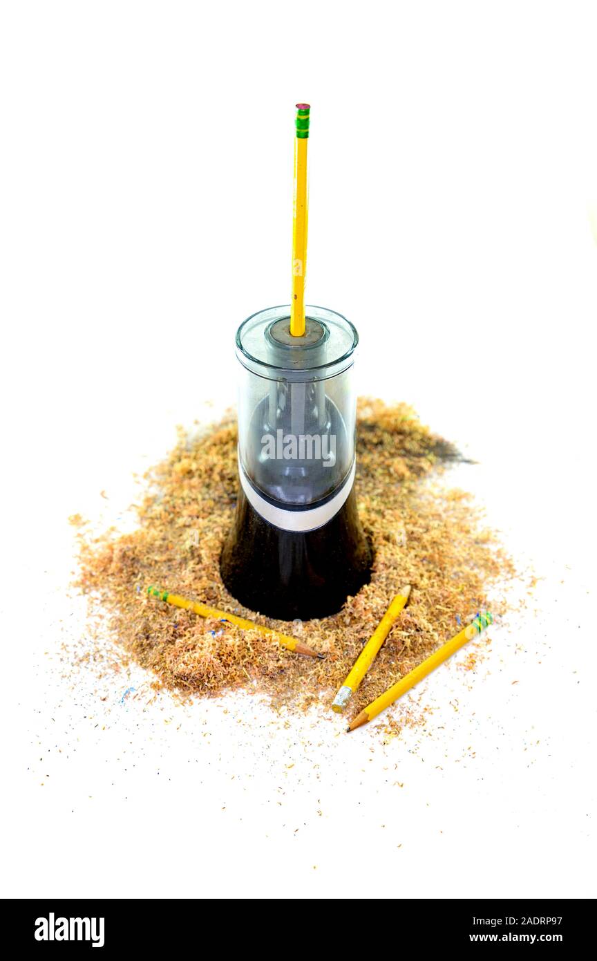 An electric pencil sharpener surrounded by pencil shavings, a pencil ...