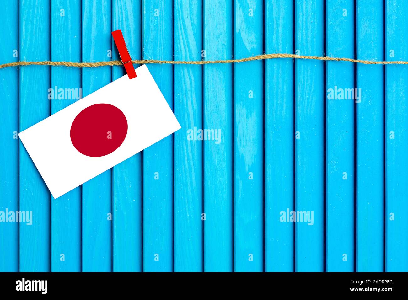 Flag of Japan hanging on clothesline attached with wooden clothespins ...