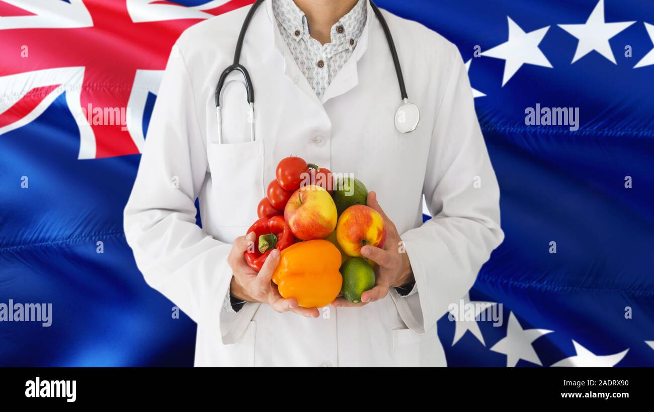 Doctor is holding fruits and vegetables in hands with Cook Islands flag ...