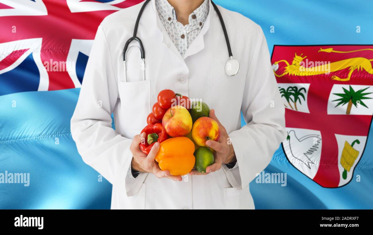 Doctor is holding fruits and vegetables in hands with Fiji flag ...
