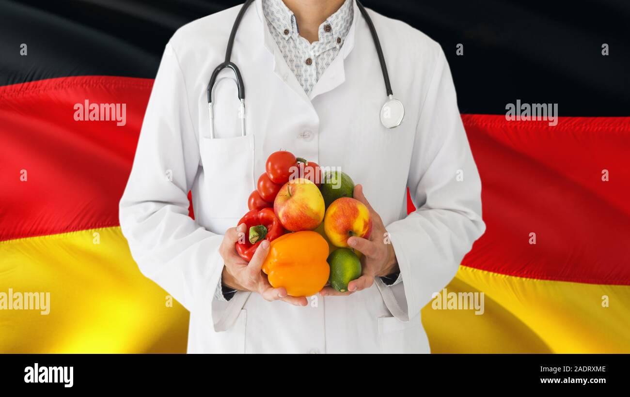 Doctor is holding fruits and vegetables in hands with Germany flag ...