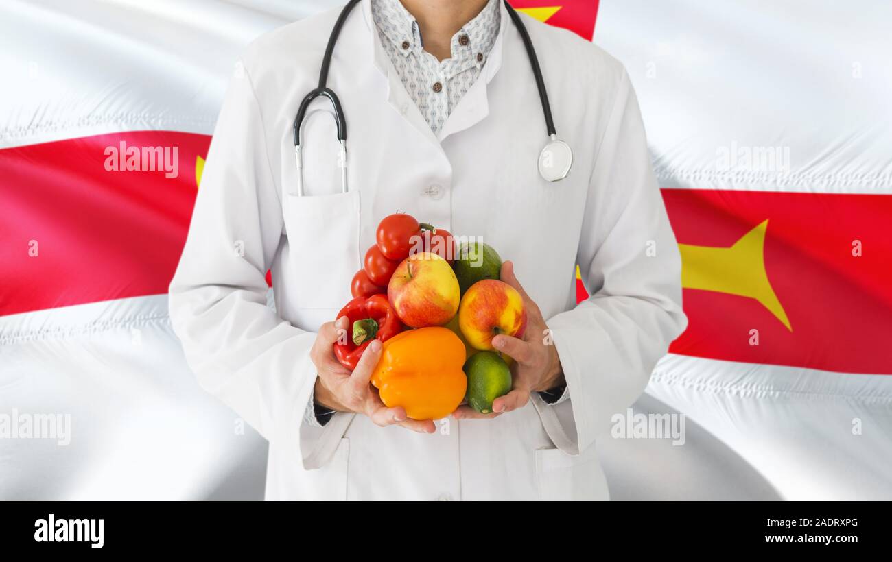 Doctor is holding fruits and vegetables in hands with Guernsey flag ...