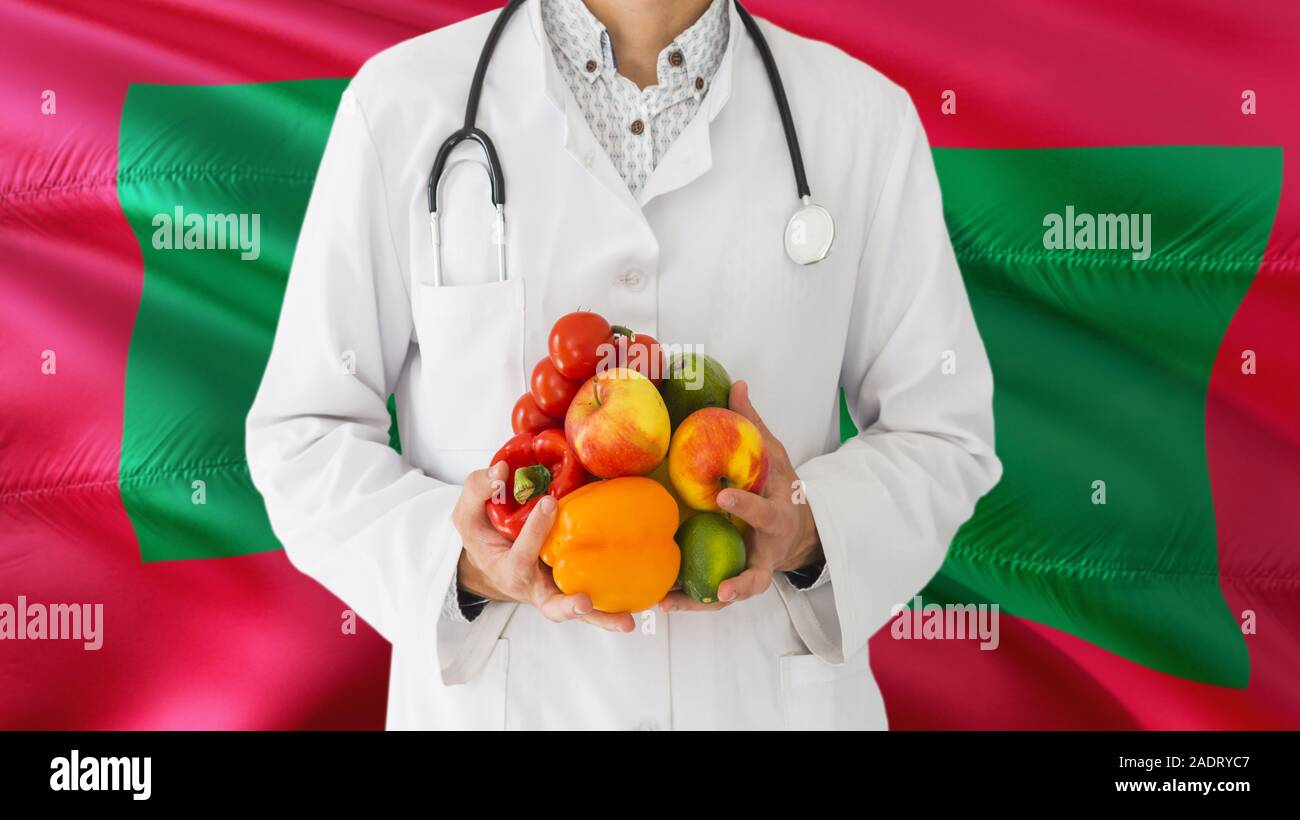 Doctor is holding fruits and vegetables in hands with Maldives flag ...