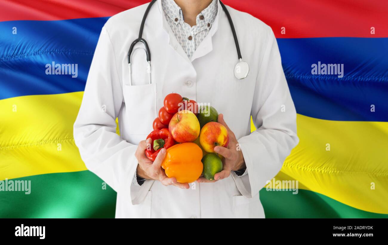 Doctor is holding fruits and vegetables in hands with Mauritius flag ...