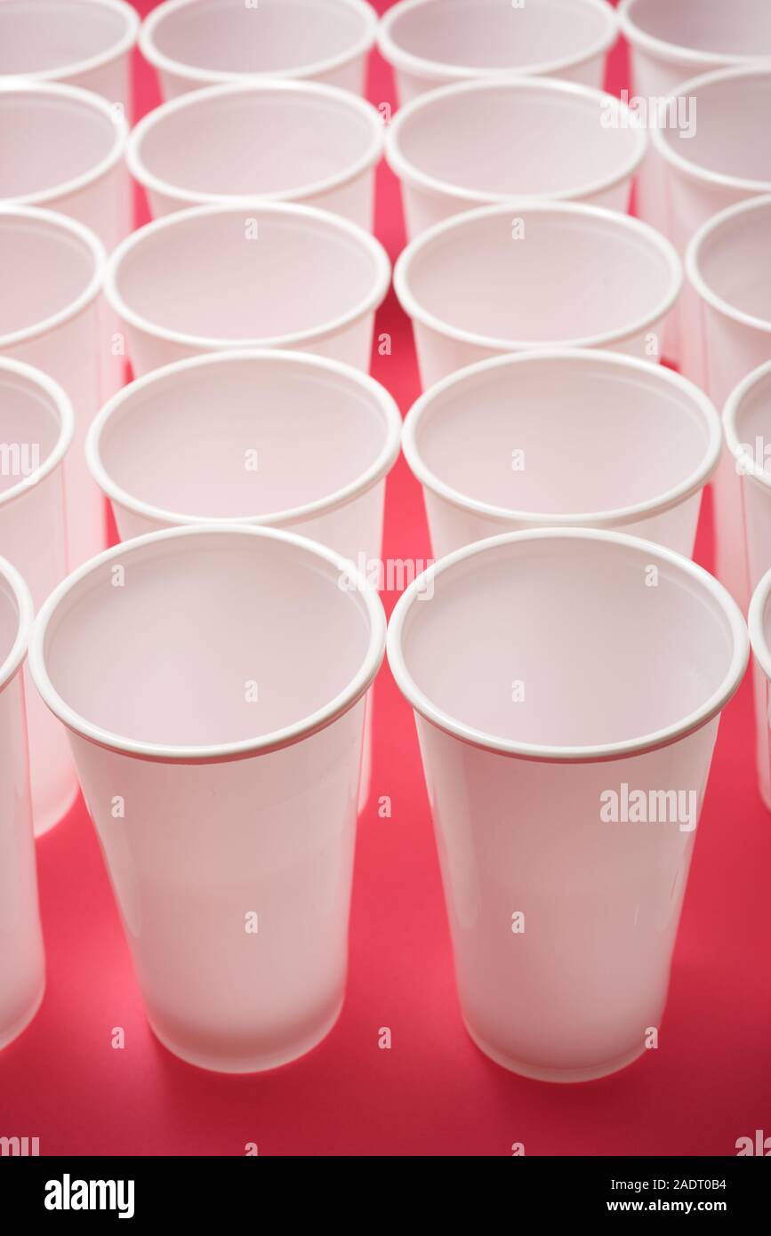 Large group of disposable plastic cups on a pink table Stock Photo - Alamy