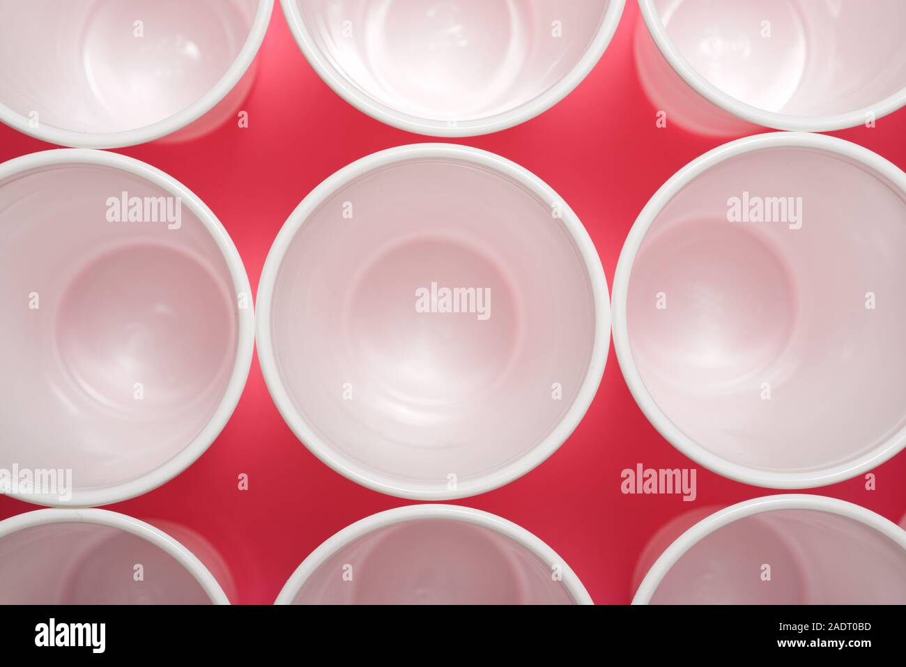 Large group of disposable plastic cups on a pink table Stock Photo - Alamy