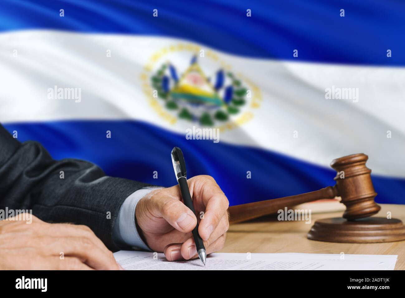 Judge Writing On Paper In Courtroom With El Salvador Flag Background