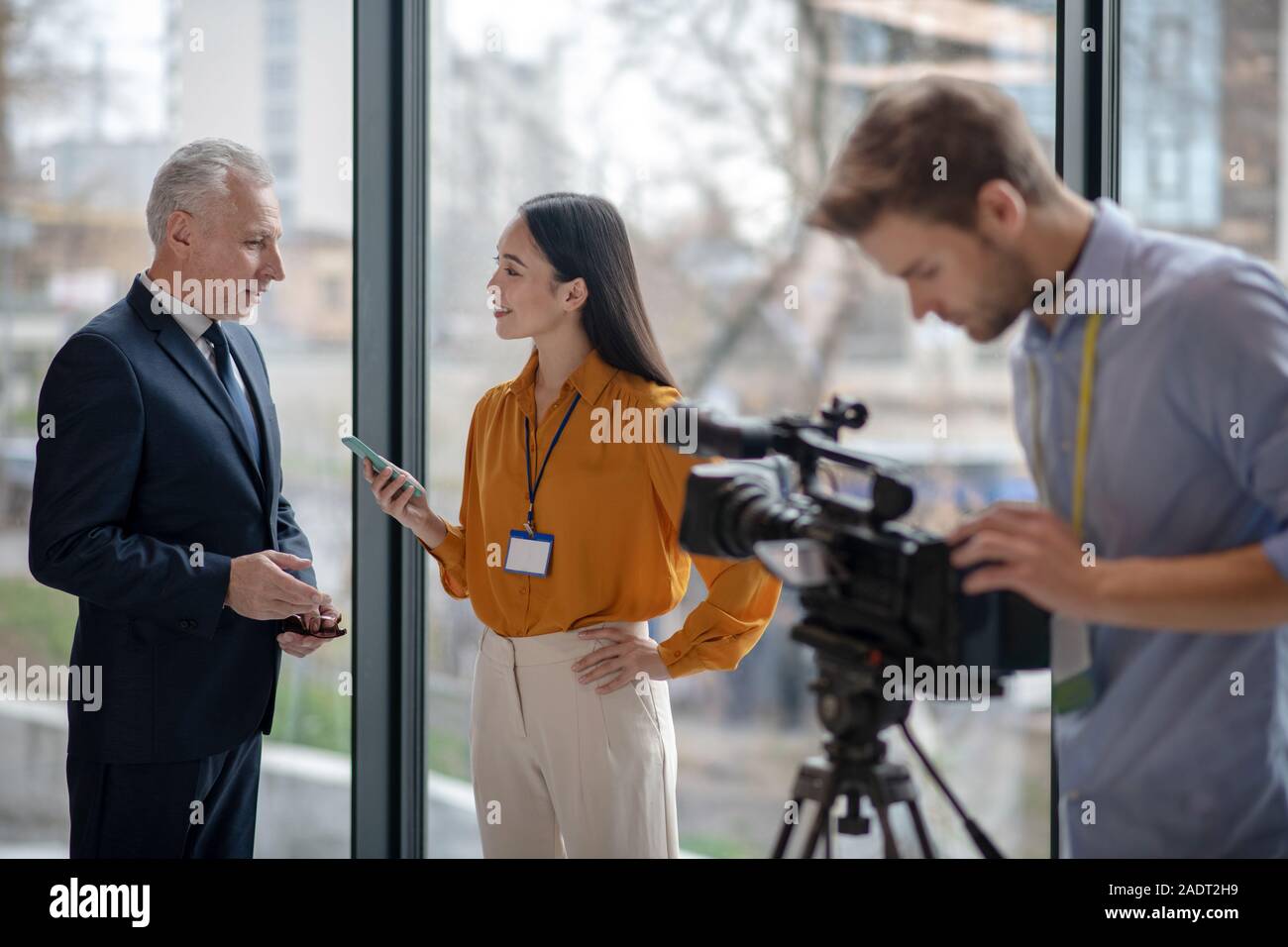 Male young operator looking busy with his video camera Stock Photo - Alamy