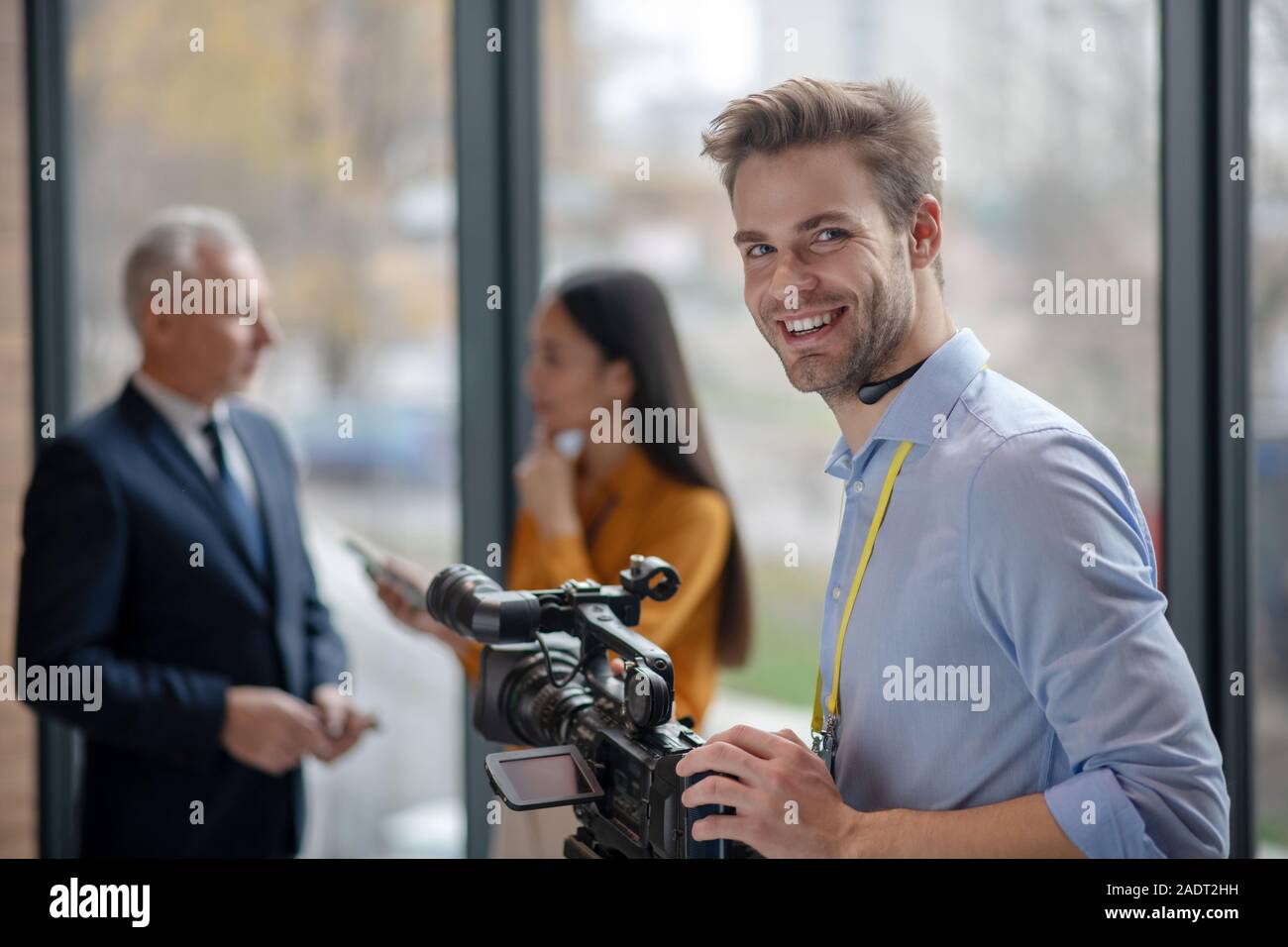 Male young operator with video camera looking satisfied Stock Photo - Alamy