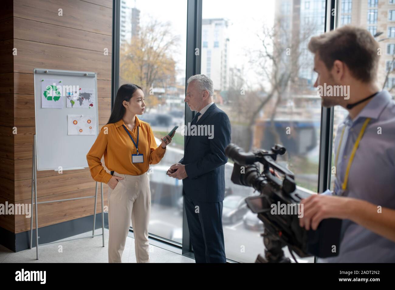 Young asian reporter explaining something to a grey-haired man Stock ...