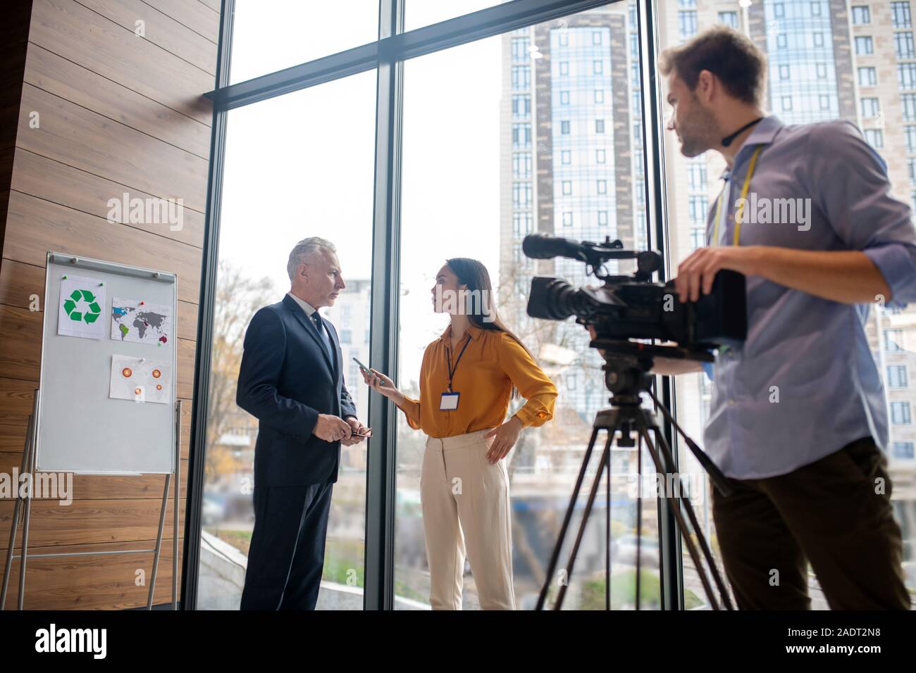 Male video operator looking at his colleague Stock Photo - Alamy