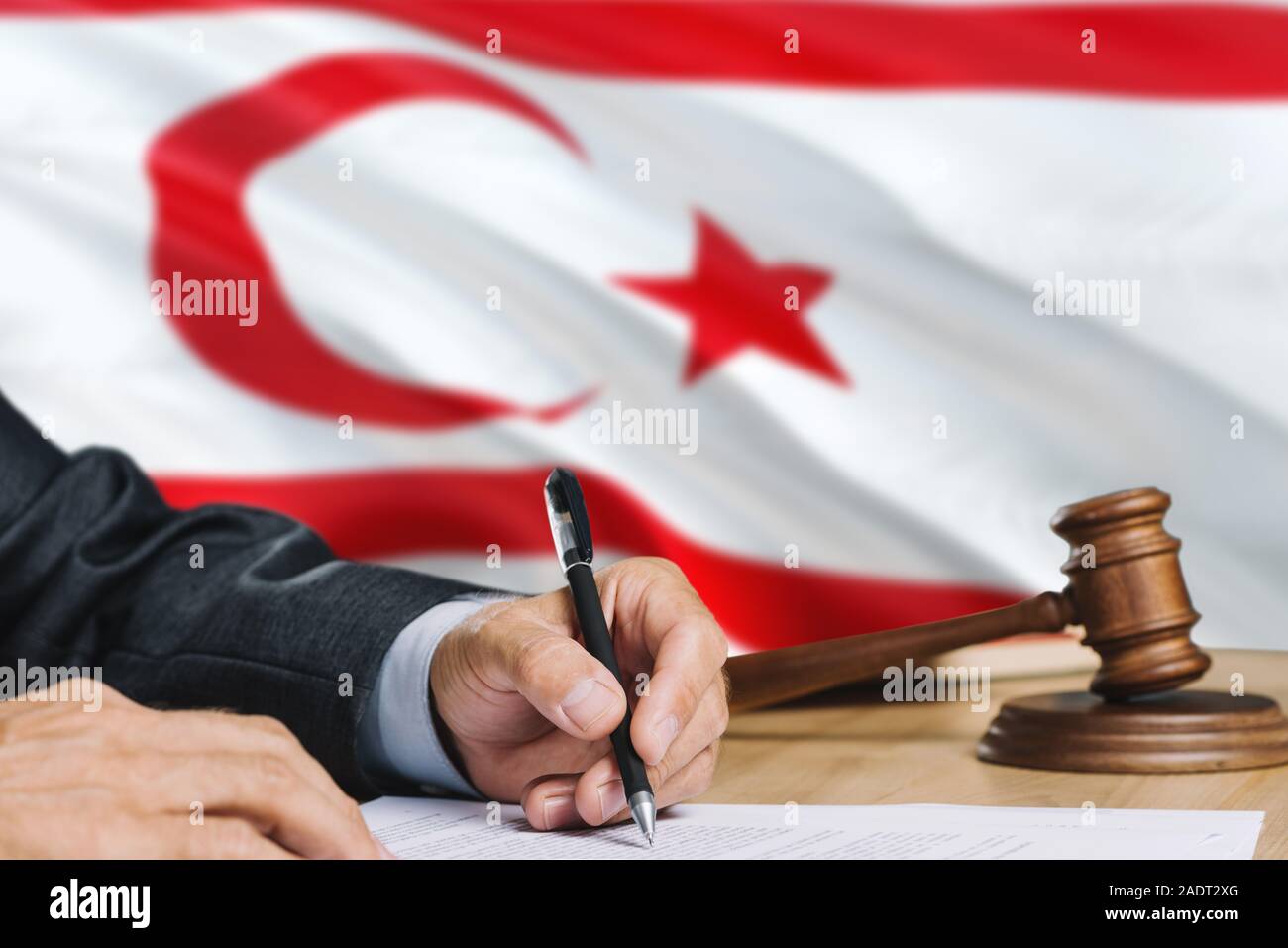 Judge writing on paper in courtroom with Northern Cyprus flag ...