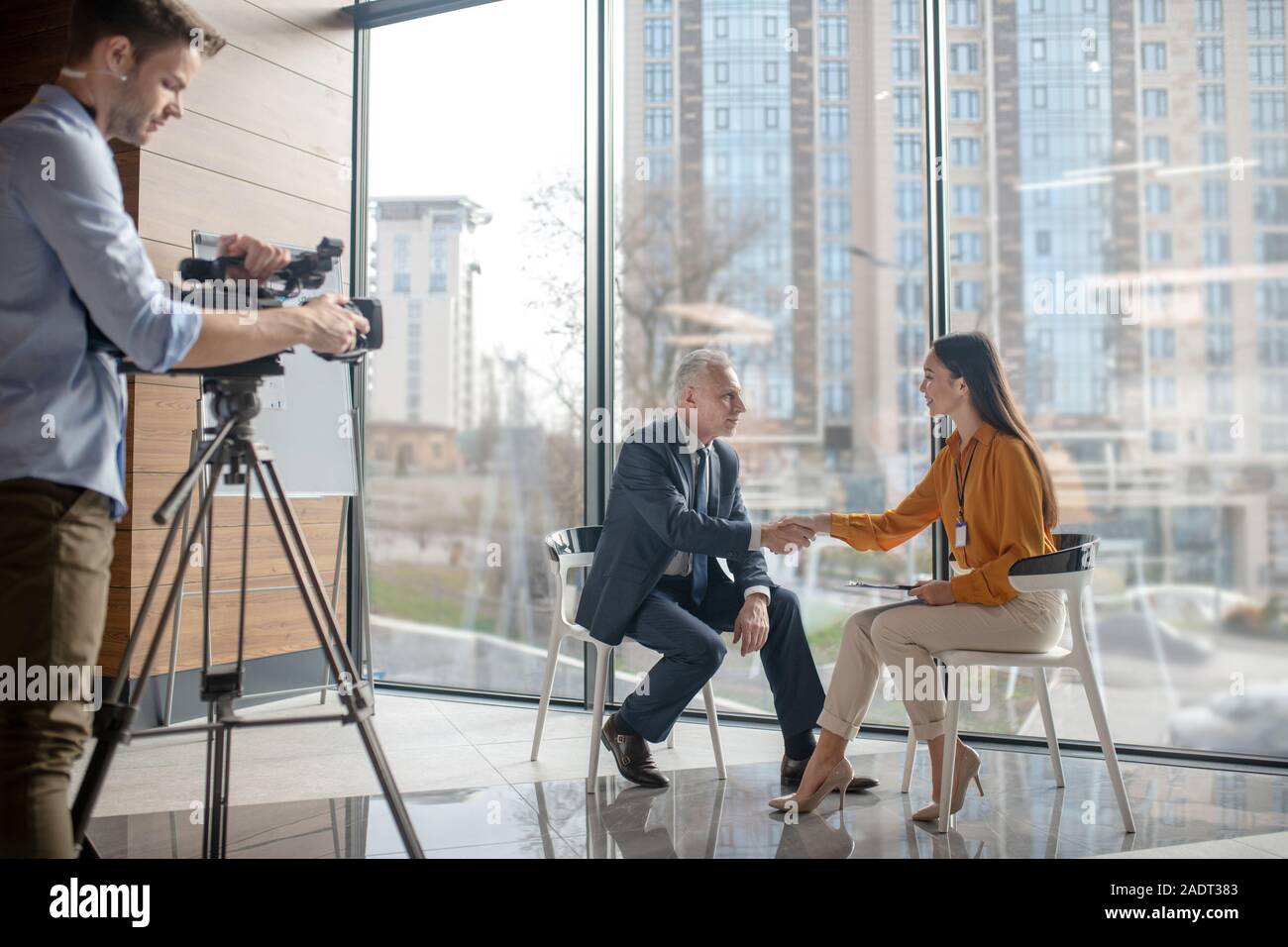 Team of reporters working on a interview with a grey-haired man Stock ...
