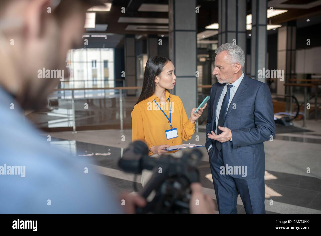 Asian female reporter talking to a famous businessman Stock Photo - Alamy