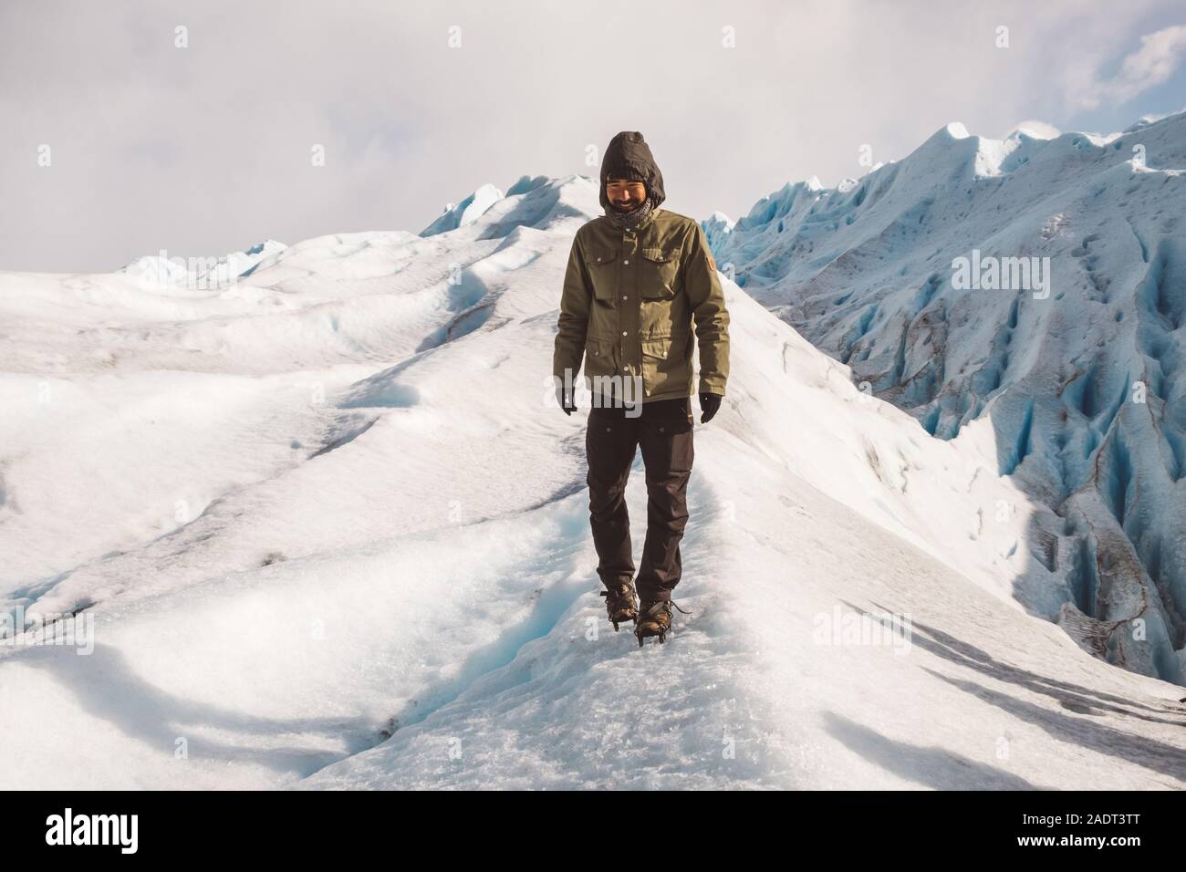 Male explorer smiling and walking on glacier Stock Photo - Alamy
