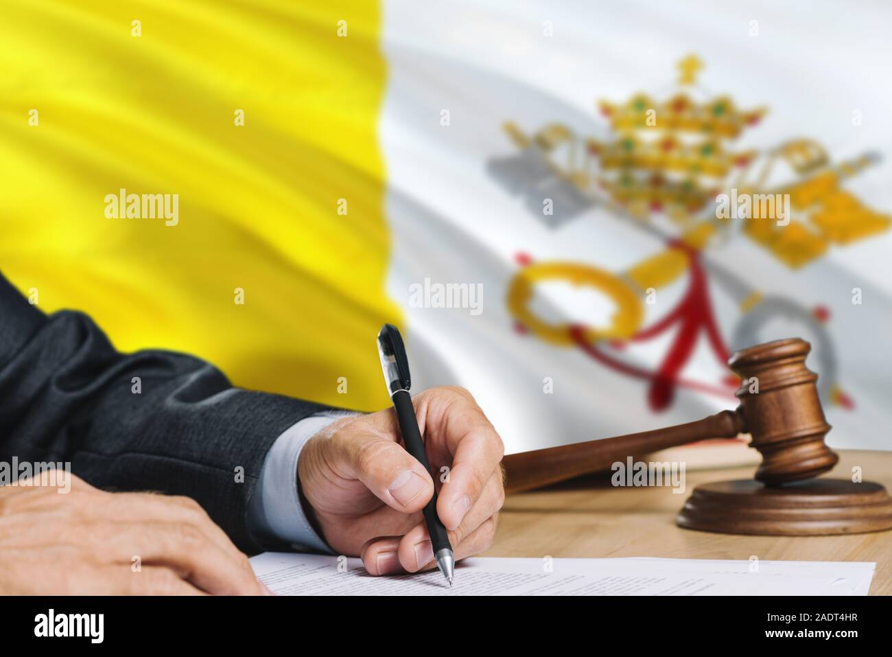 Judge writing on paper in courtroom with Vatican City flag background ...
