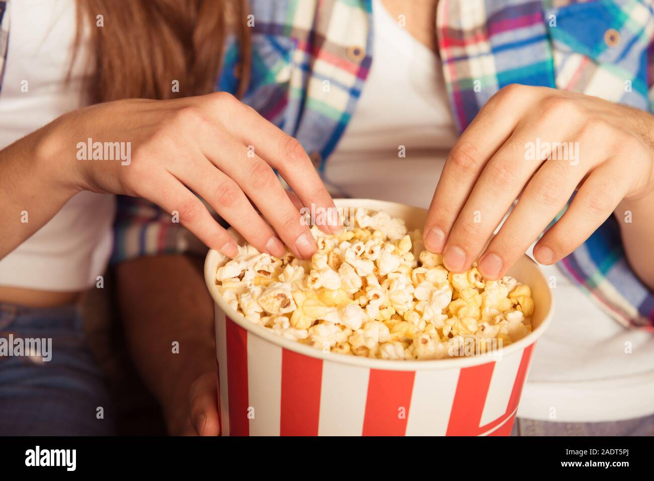 young woman and man eating popcorn in the cinema Stock Photo - Alamy