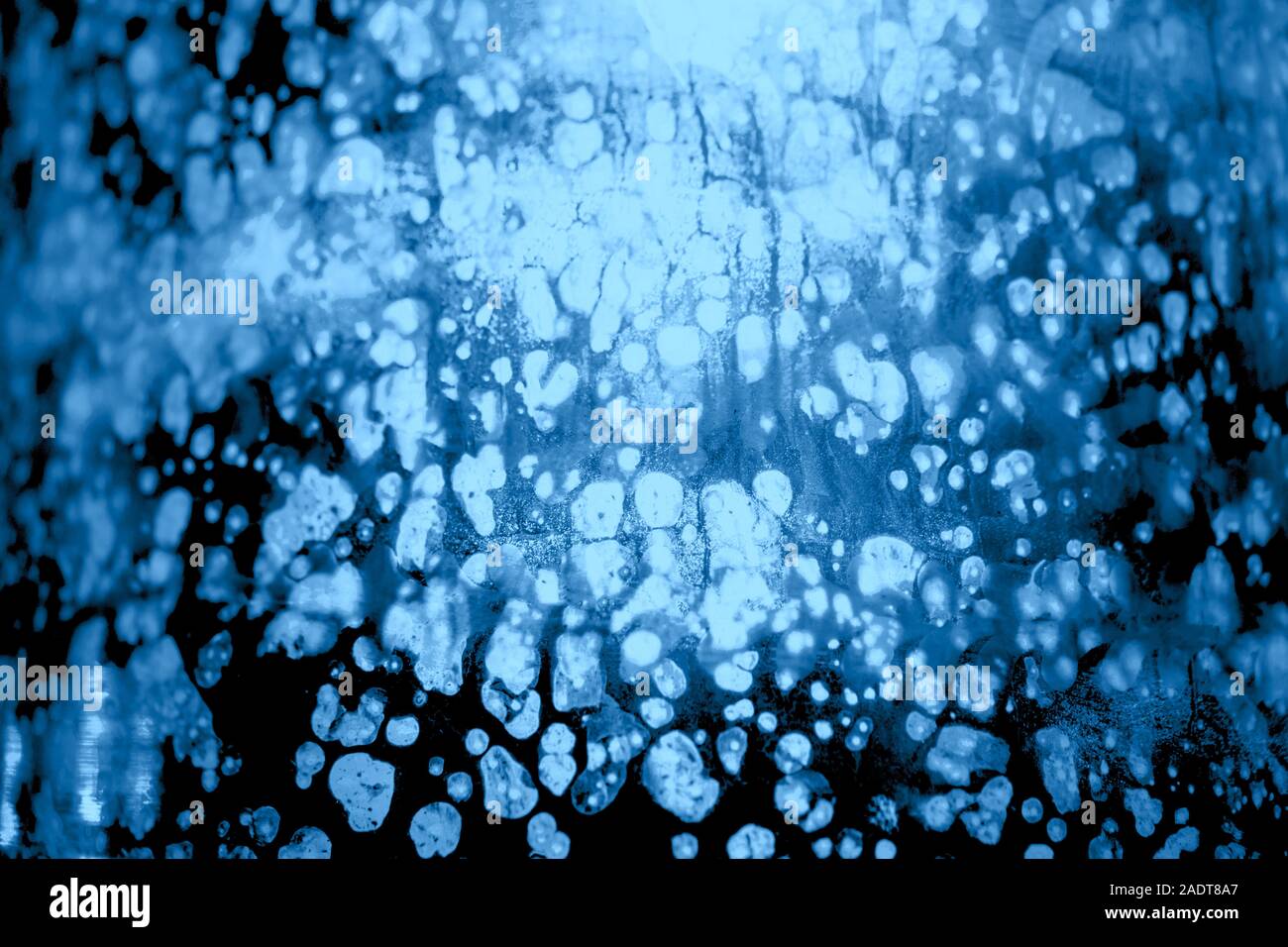 Bright blurred chandelier texture in blue color spots on a black ...