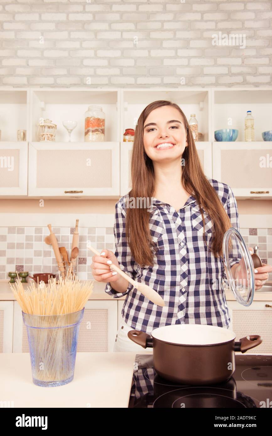 Pretty young girl boiling spaghetti in the kitchen Stock Photo - Alamy
