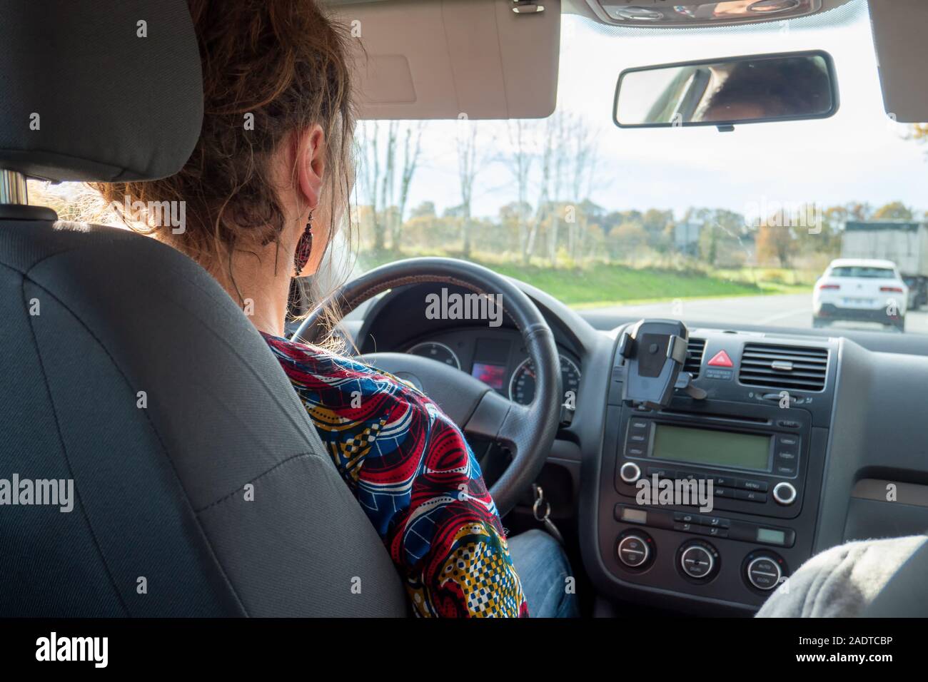 a young woman driving car. Wide angle interior view Stock Photo - Alamy