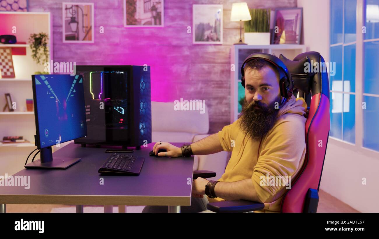 Man sitting on a gaming chair and playing video games in his room with ...