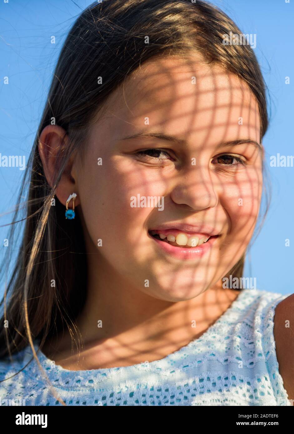 Child pleased with warm sunlight looks relaxed blue sky background ...