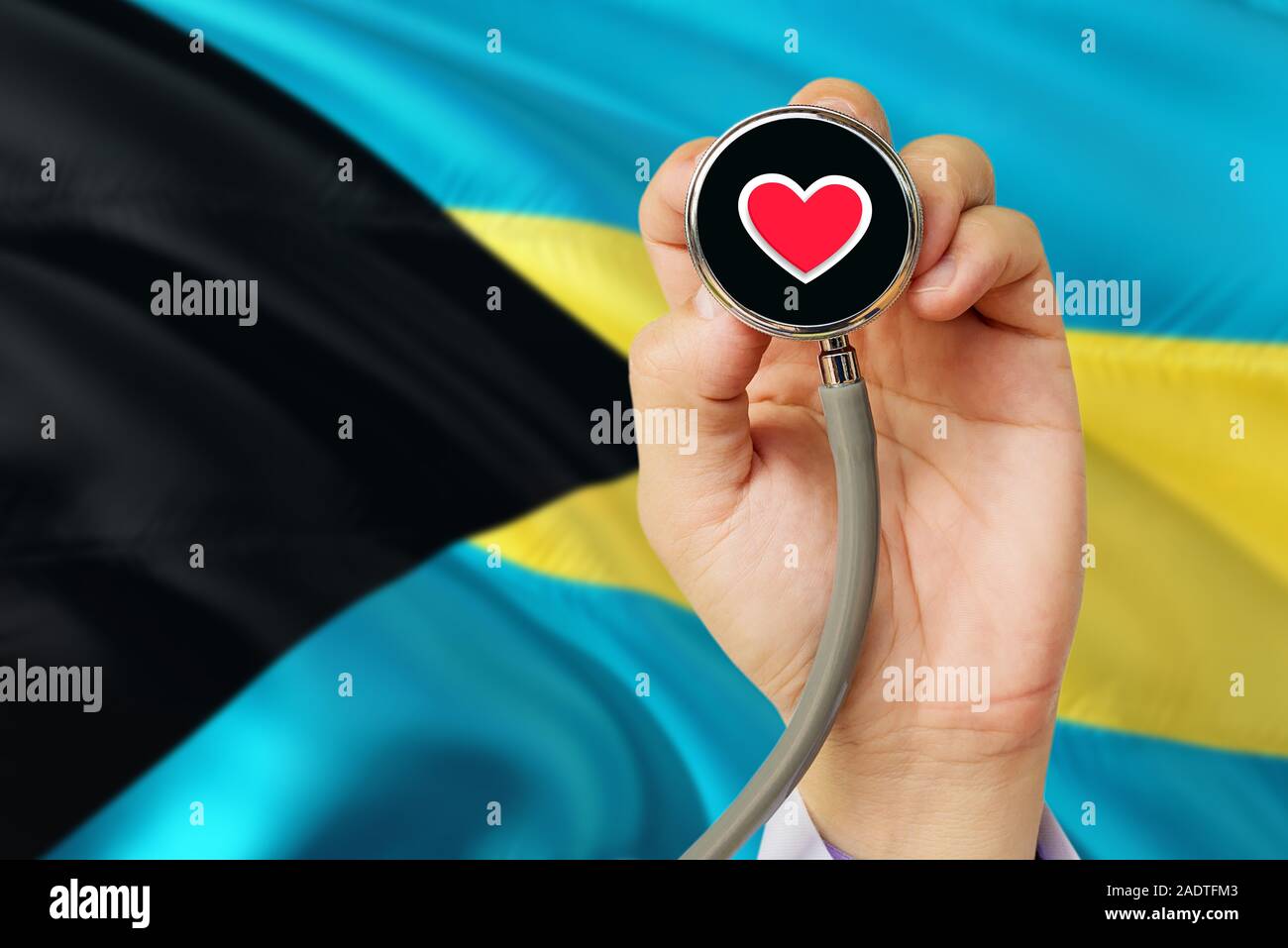 Doctor holding stethoscope with red love heart. National Bahamas flag ...