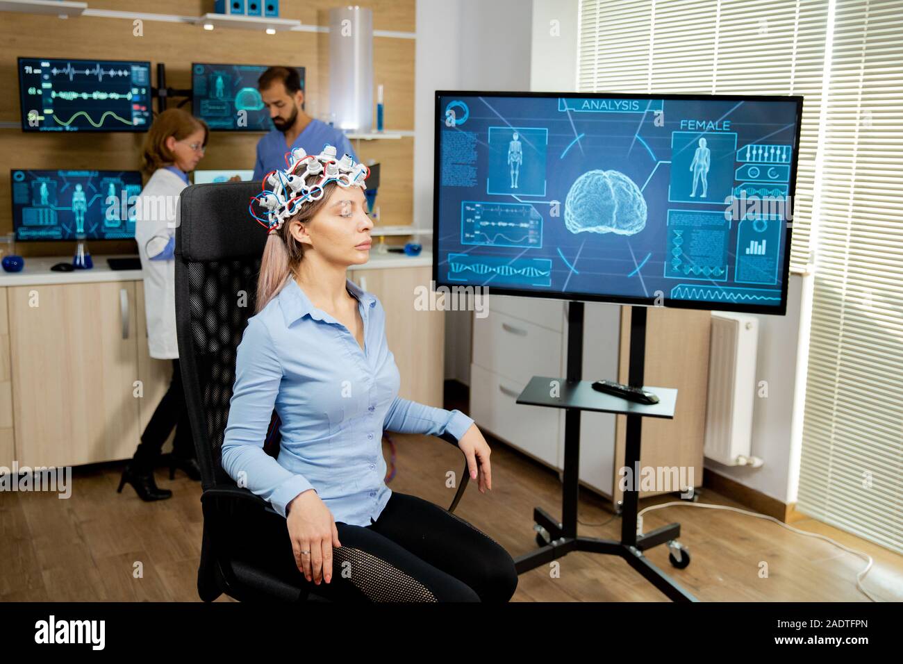 Patient woman with head scanning device and brain activity is seen on ...