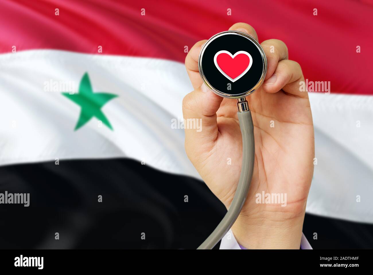 Doctor holding stethoscope with red love heart. National Syria flag ...