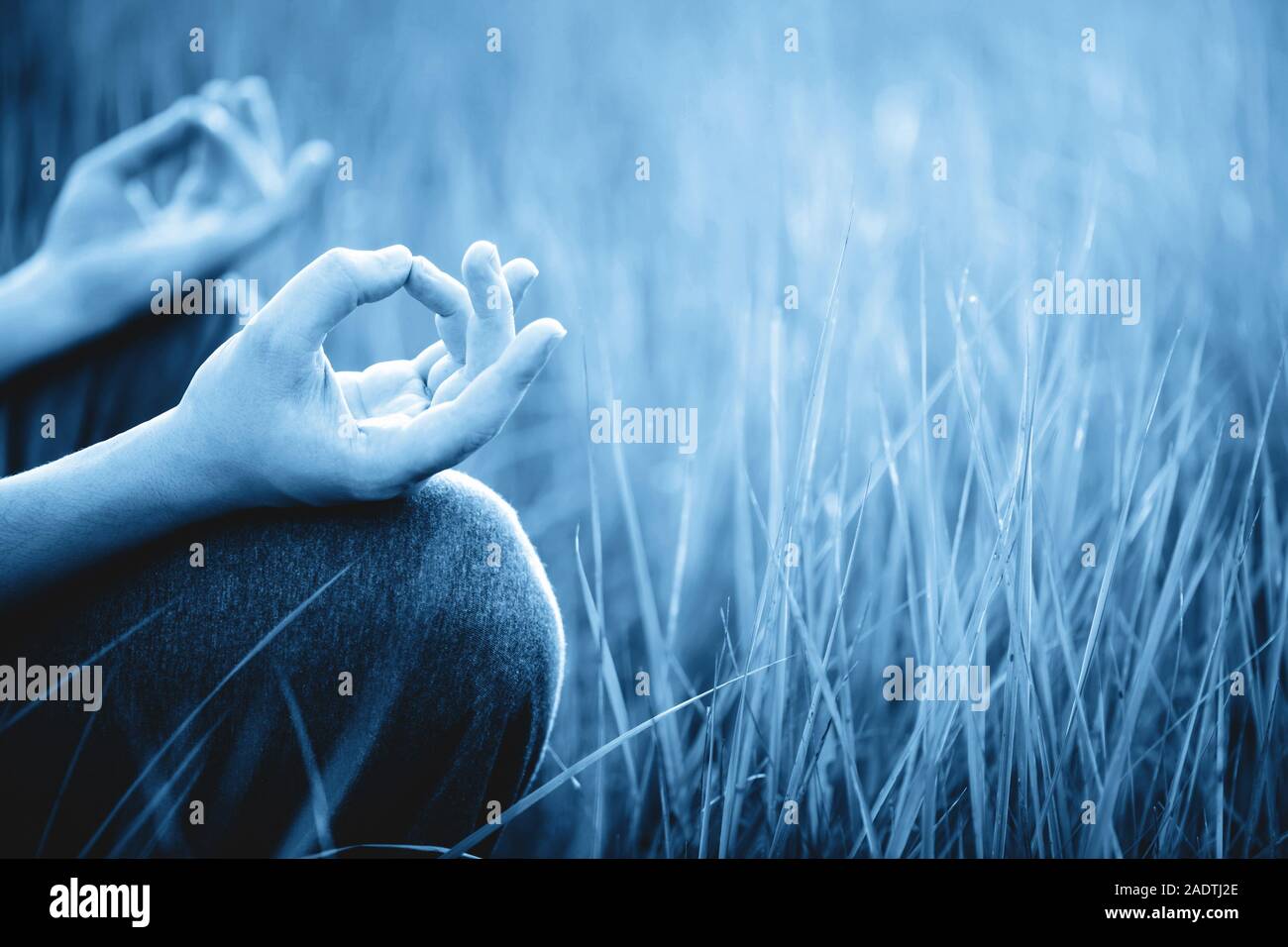 Photo of man meditating outdoor in the park in blue tones. Healthy and ...