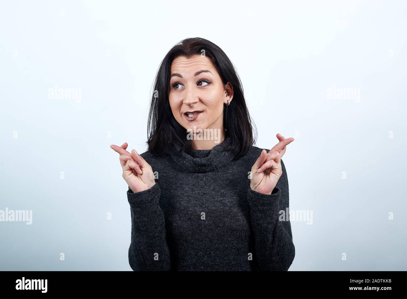 Attractive lady holding fingers crossed, waiting for special moment ...