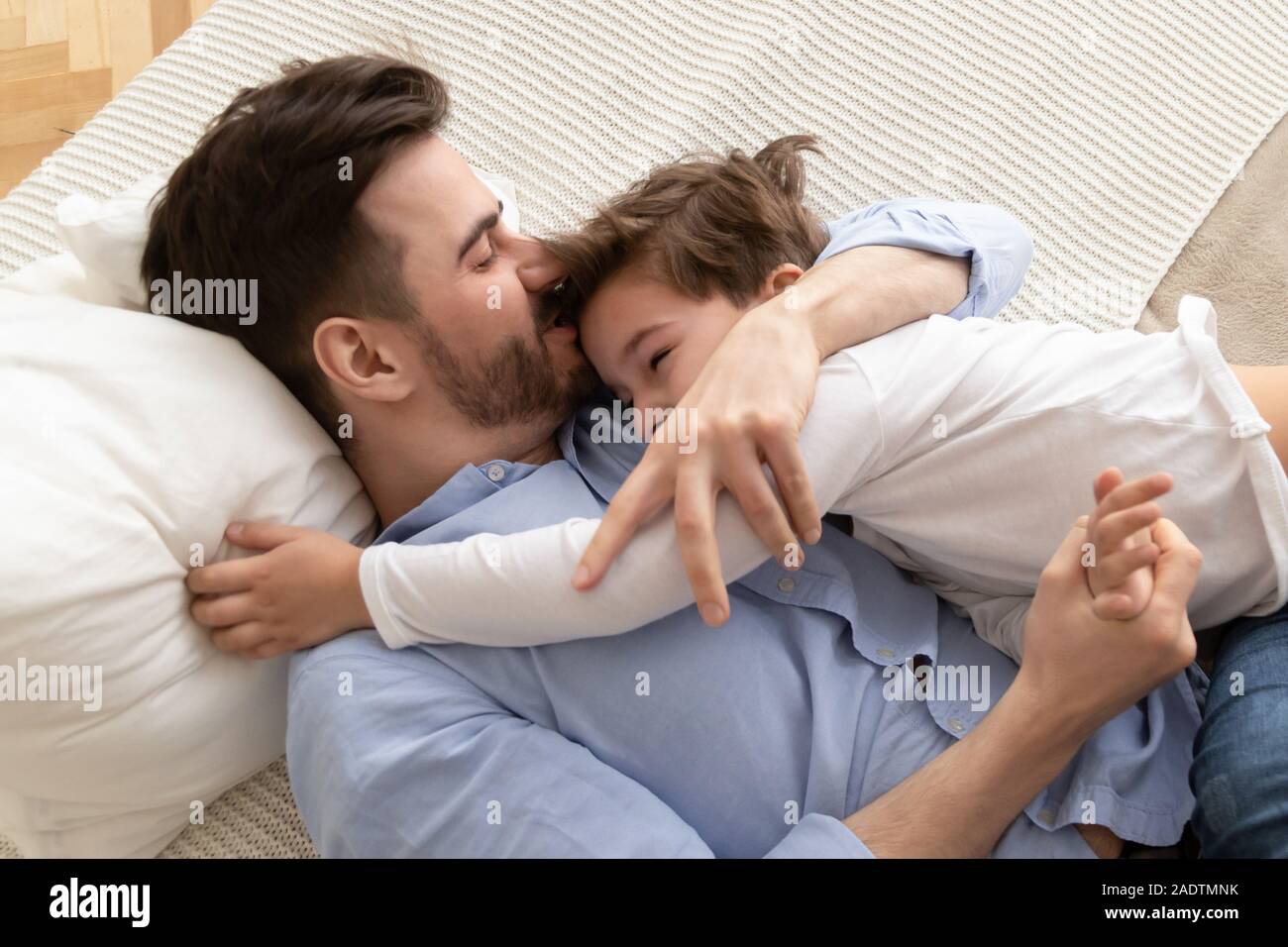 Above view father hugs little son family lying on bed Stock Photo - Alamy