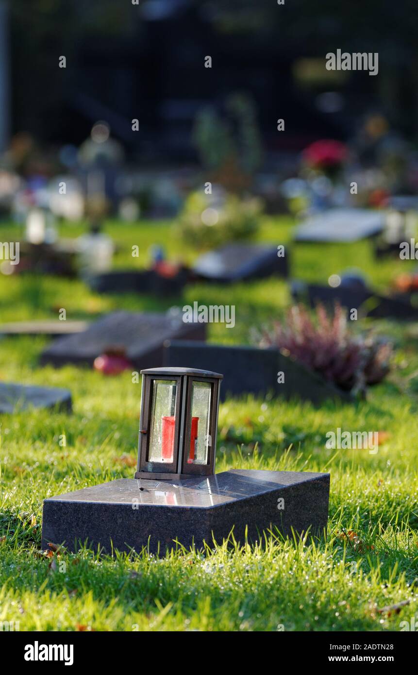 lantern on a gravestone of a cemetery with pauper graves against ...