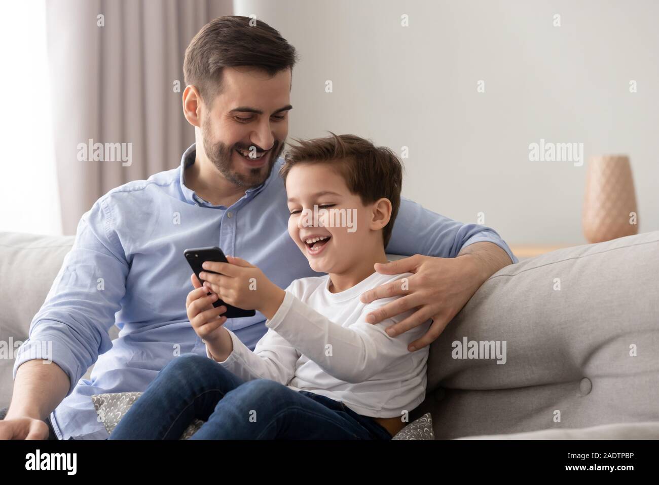 Father son using smartphone sitting hi-res stock photography and images ...