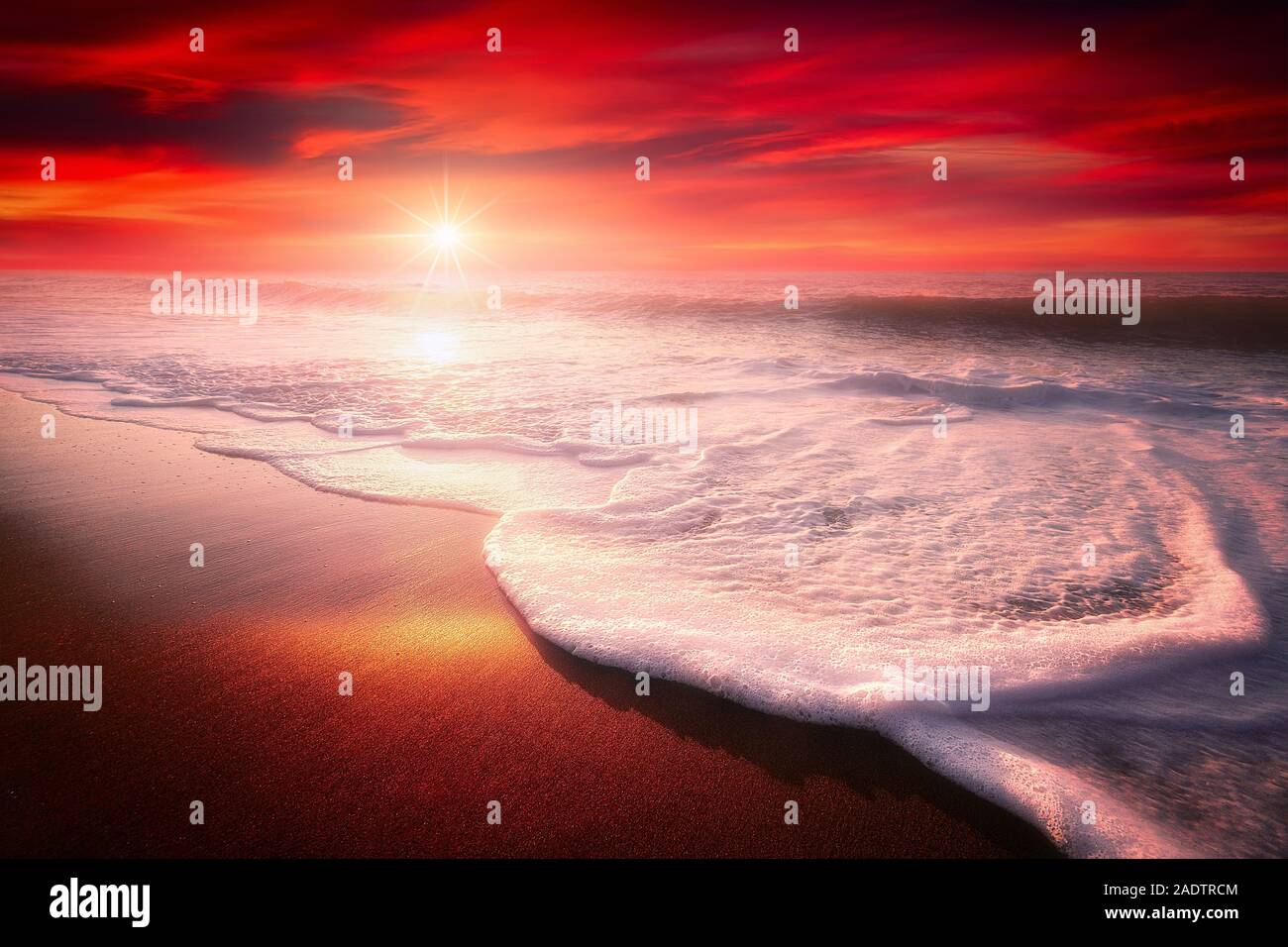 red sunset on beach with a wave on the shore Stock Photo - Alamy